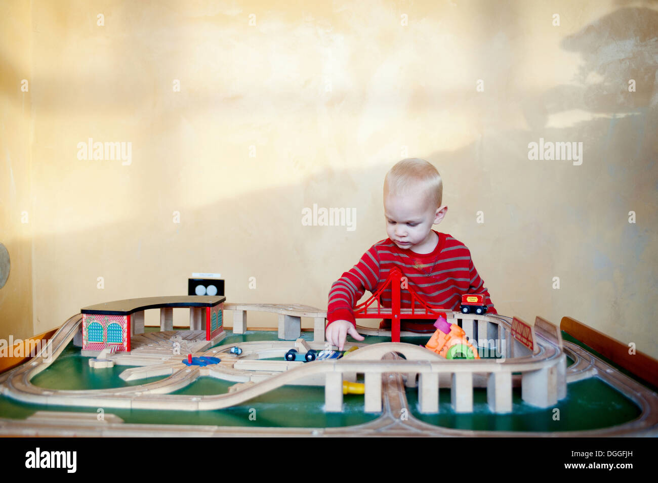 Young boy playing with toy train set Stock Photo - Alamy