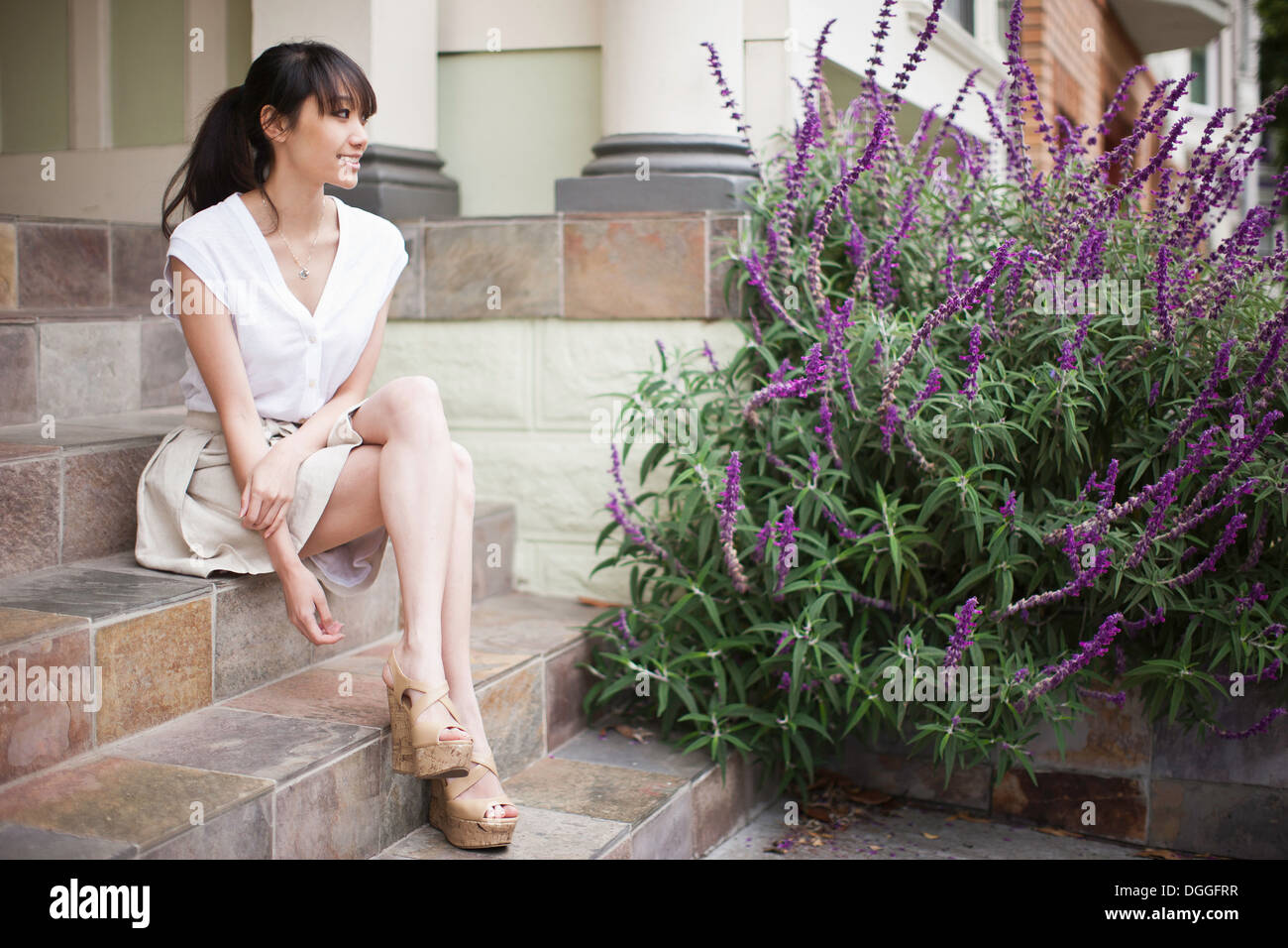Portrait of young girl sitting on steps at home Stock Photo - Alamy