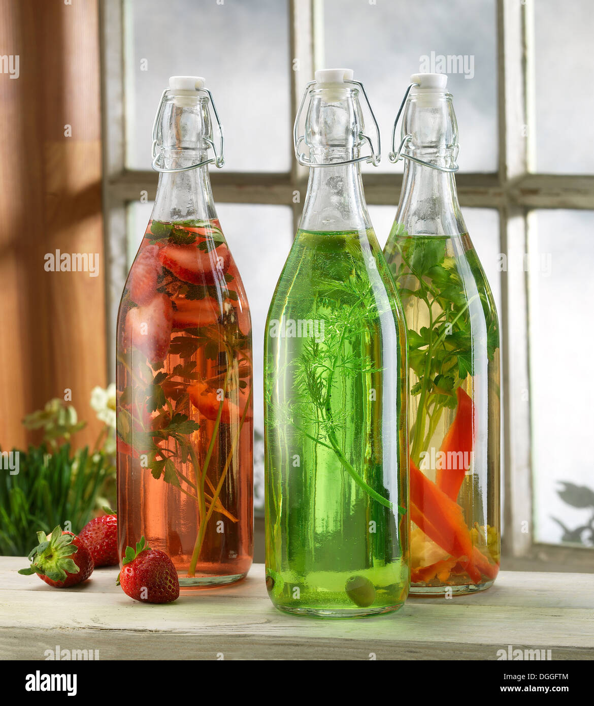 Three bottles of pickled herbs on windowsill Stock Photo - Alamy