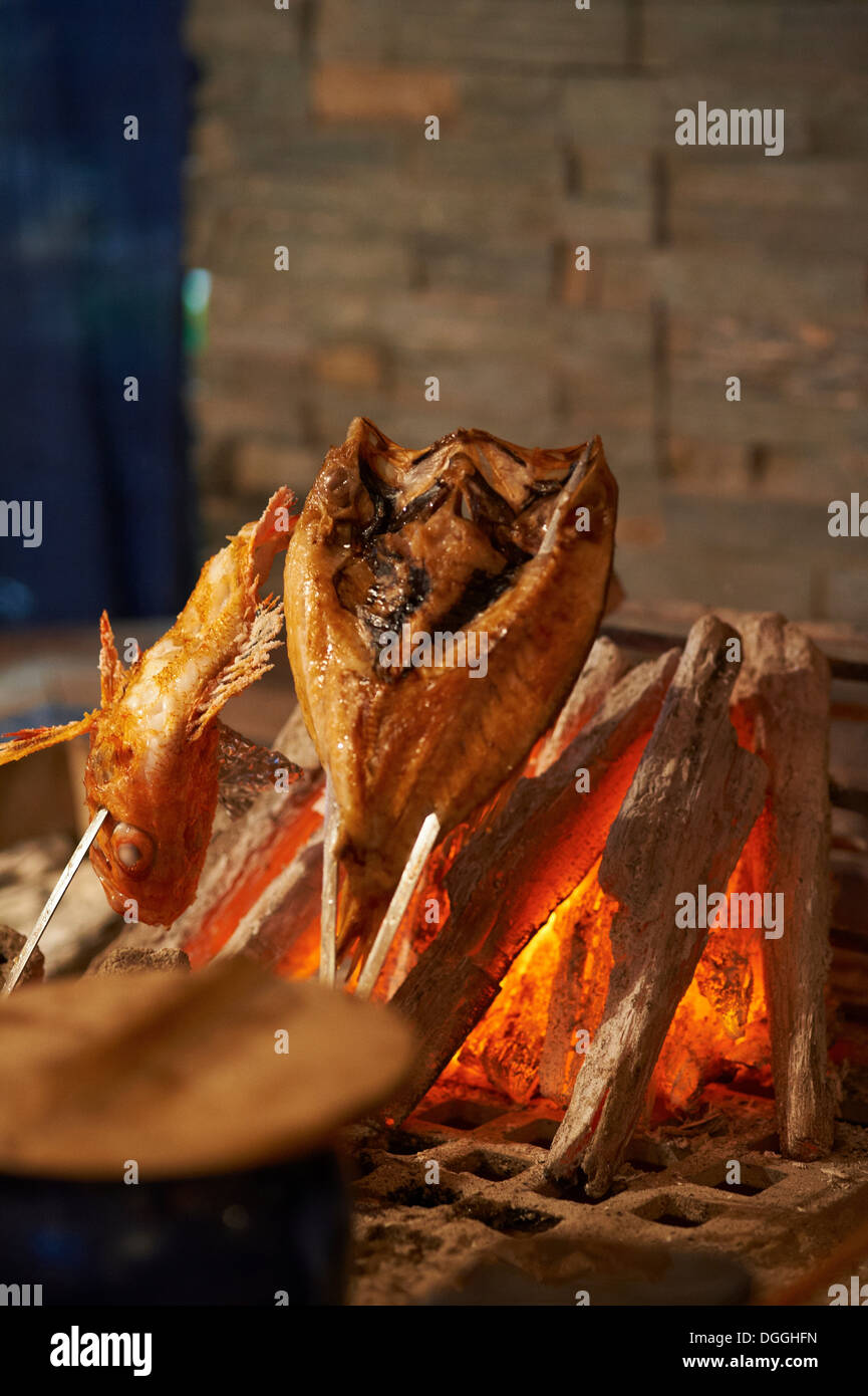 Still life with fish cooking on charcoal Stock Photo - Alamy
