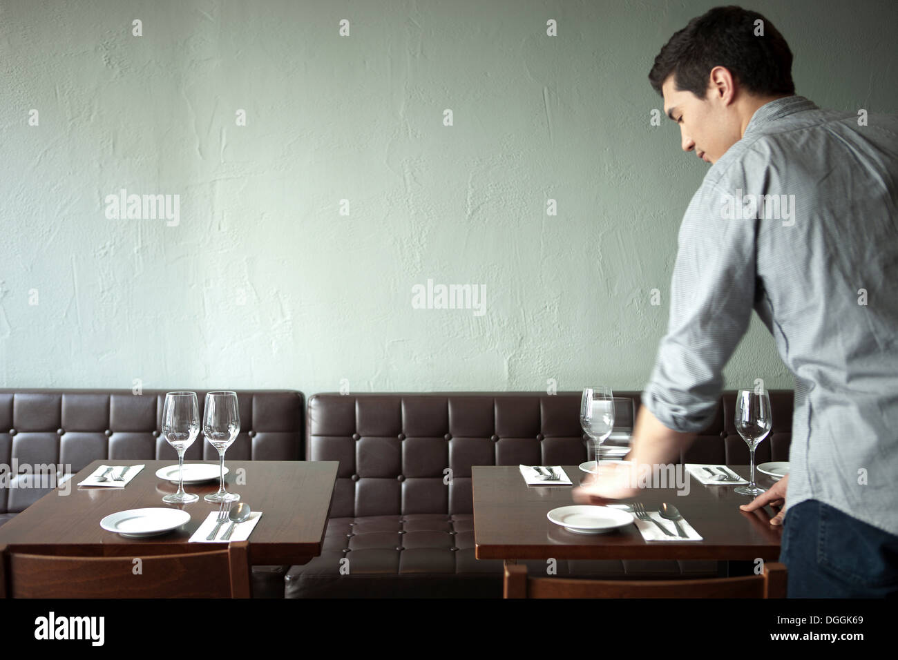 Waiter setting table in restaurant Stock Photo - Alamy