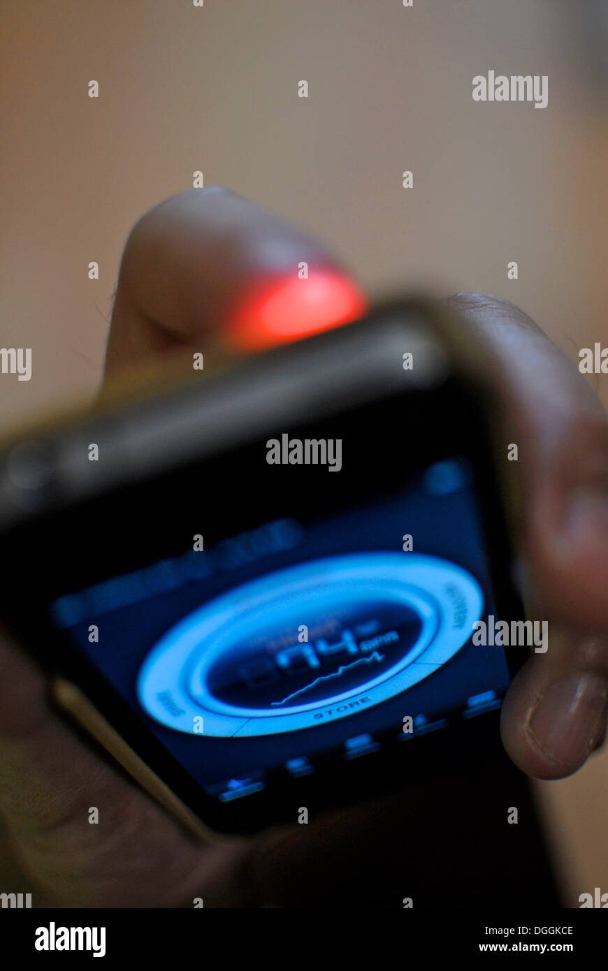 Young man using iPhone App for measuring heart rate Stock Photo - Alamy