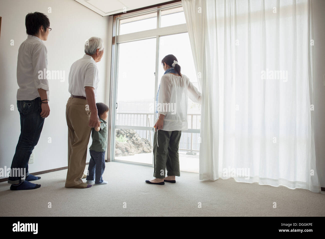 Three generation family standing by window Stock Photo - Alamy