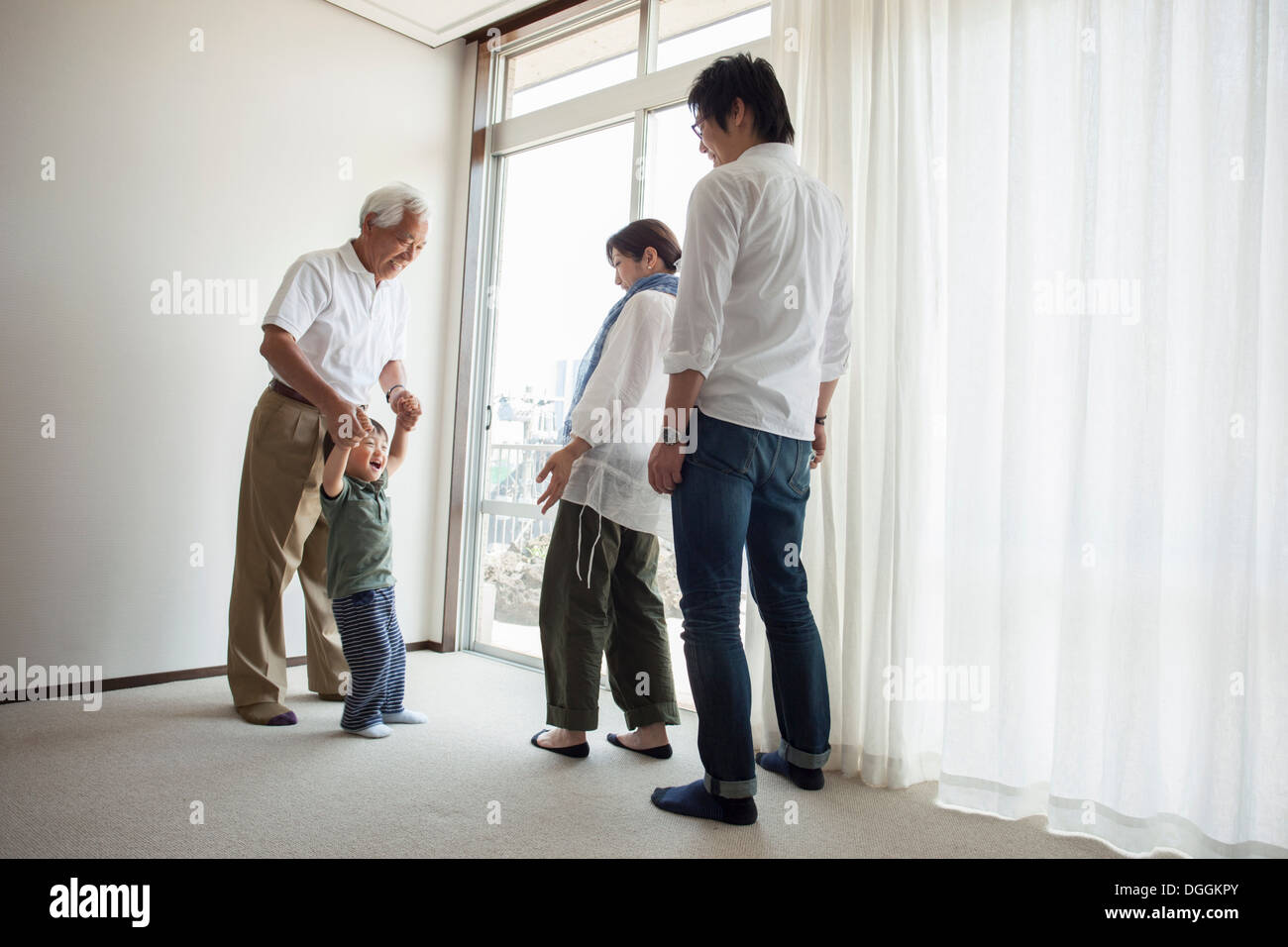 Three generation family standing by window Stock Photo - Alamy