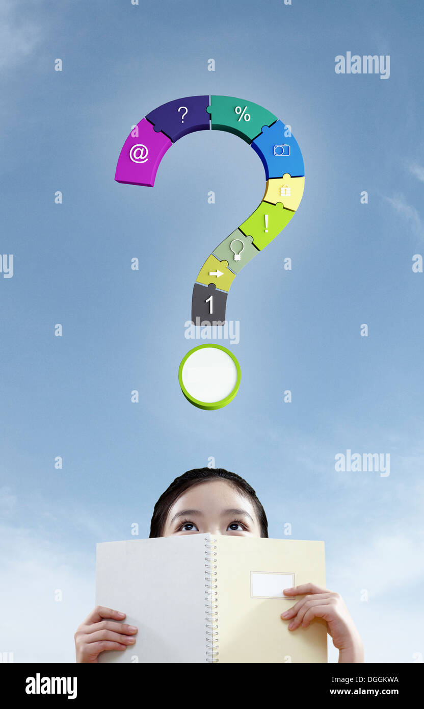 a girl reading a book with a question mark Stock Photo - Alamy