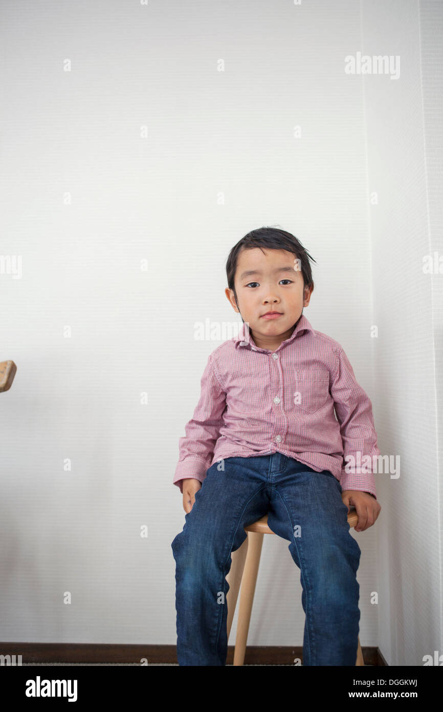 Boy sitting on stool, portrait Stock Photo - Alamy