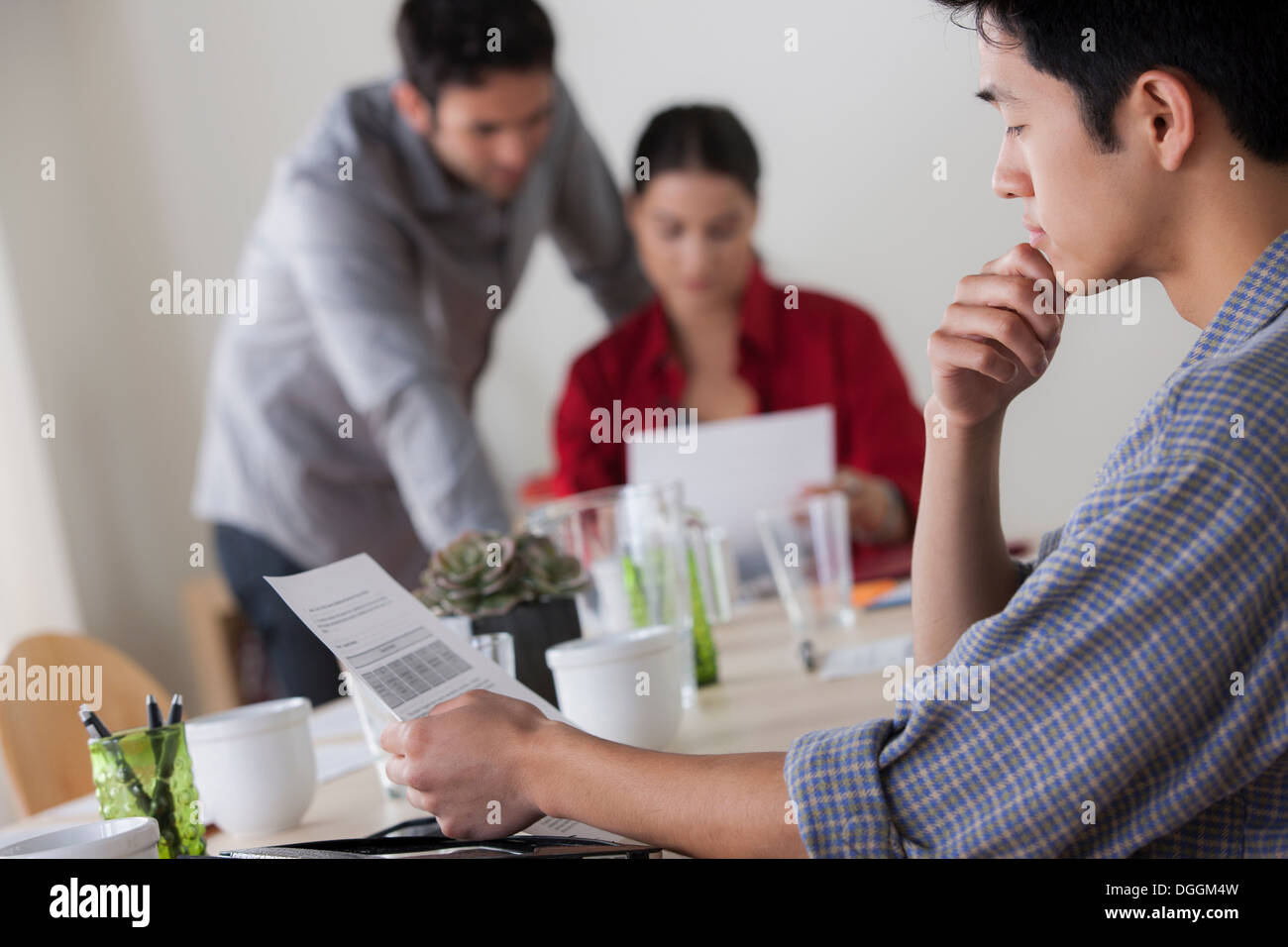 Male office worker reading papers at desk Stock Photo - Alamy