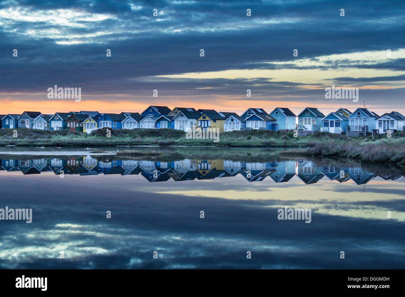 Beach huts on Mudeford Spit reflected in the lagoon at sunrise Stock ...