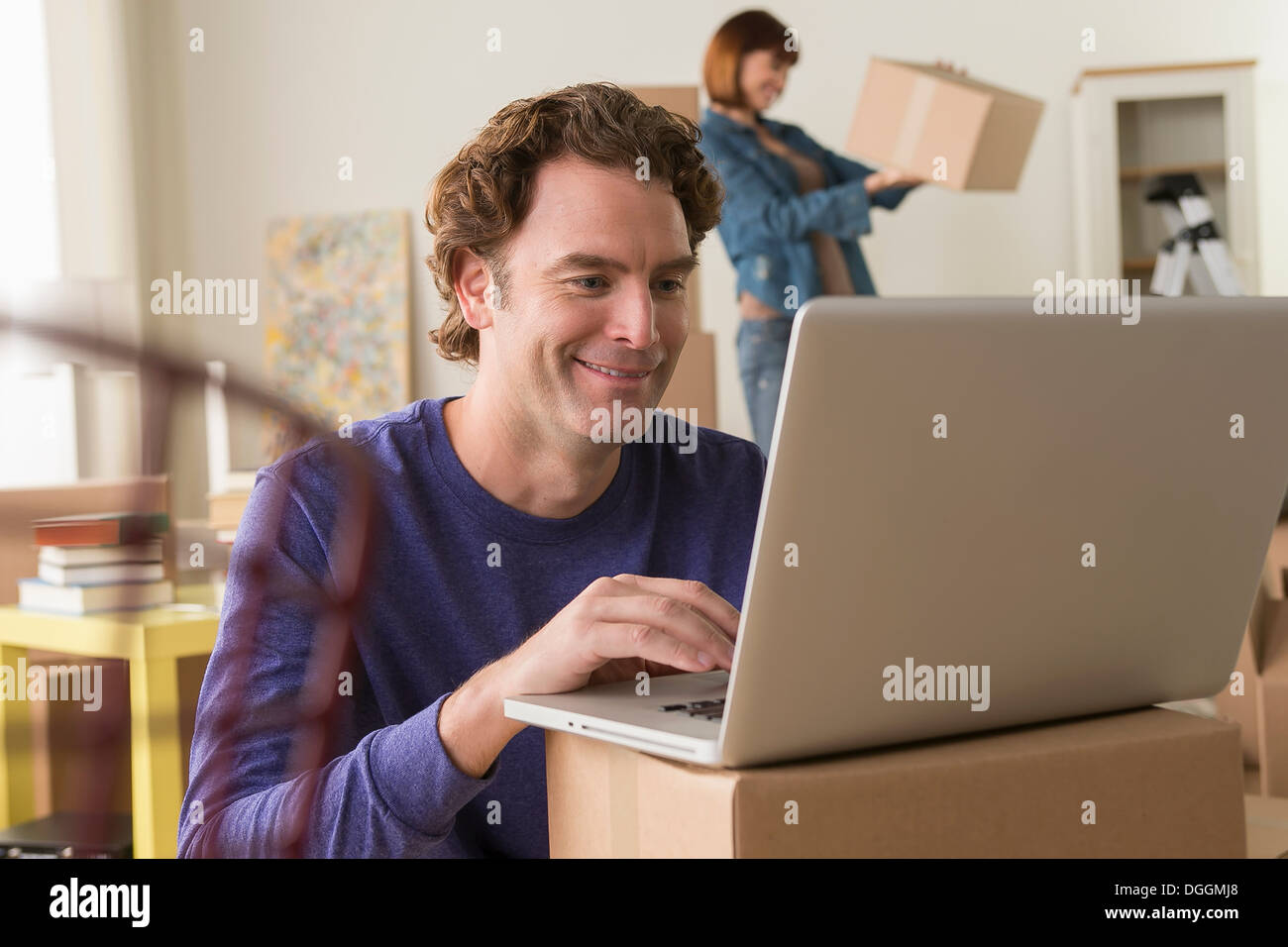 Mature man using computer whilst moving house Stock Photo - Alamy
