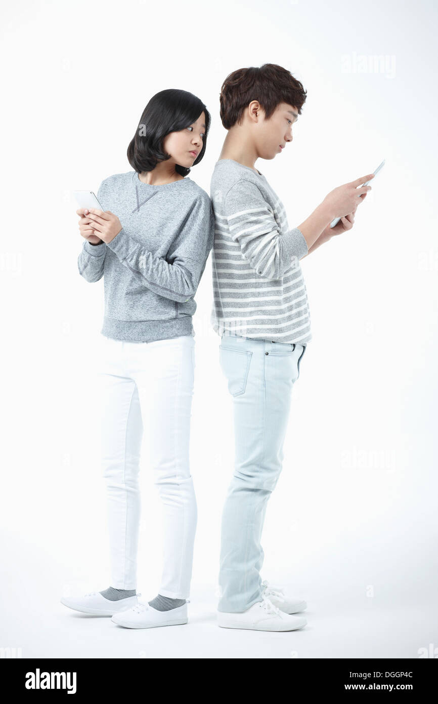 a boy and a girl with a smartphone and a tablet Stock Photo - Alamy