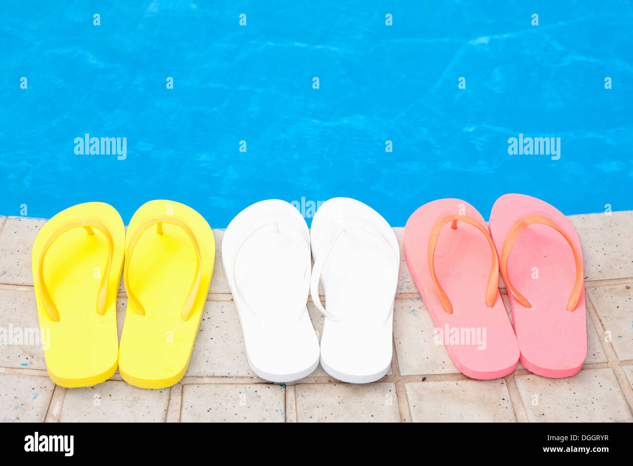 three pairs of flip flops next to a pool Stock Photo - Alamy