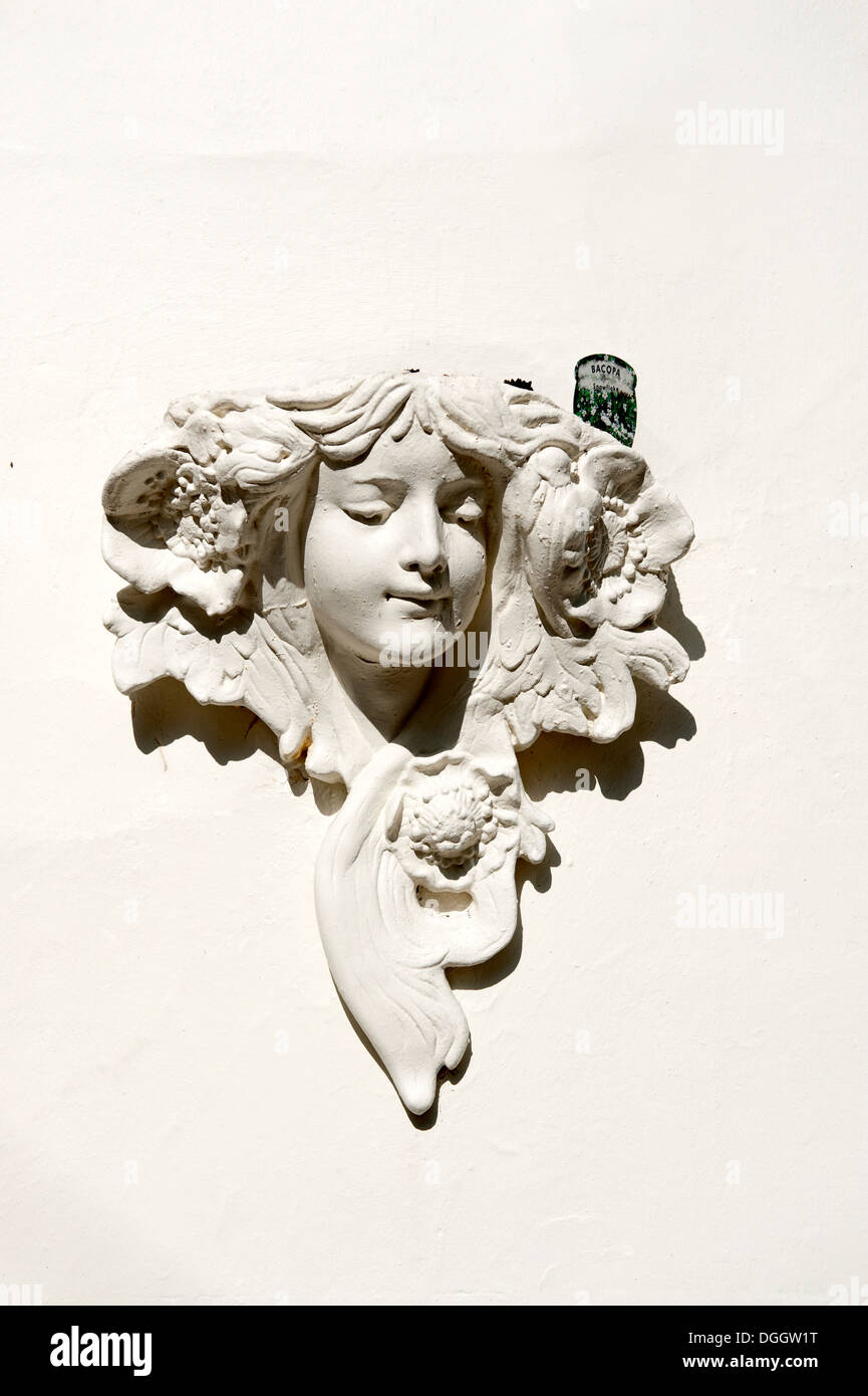 Sculpture of Cherub Face and flowers on wall Stock Photo - Alamy