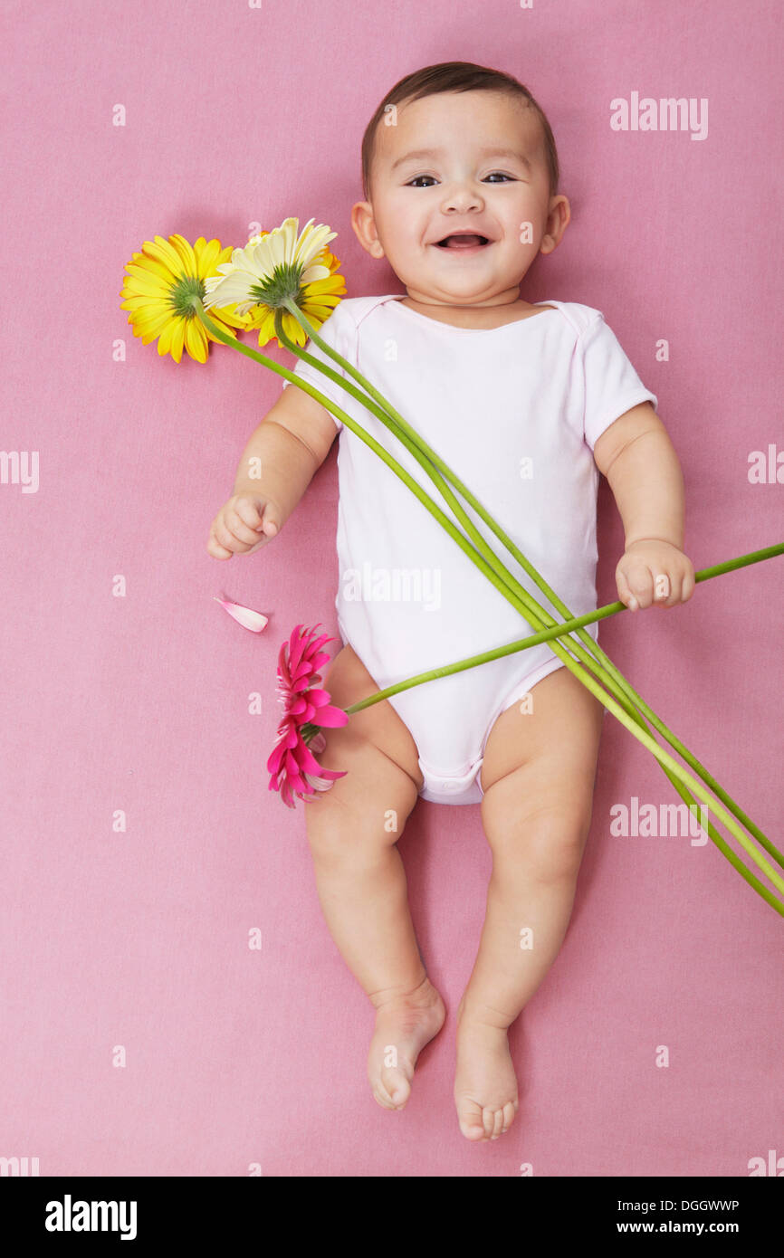 Baby girl with gerbera flowers Stock Photo - Alamy