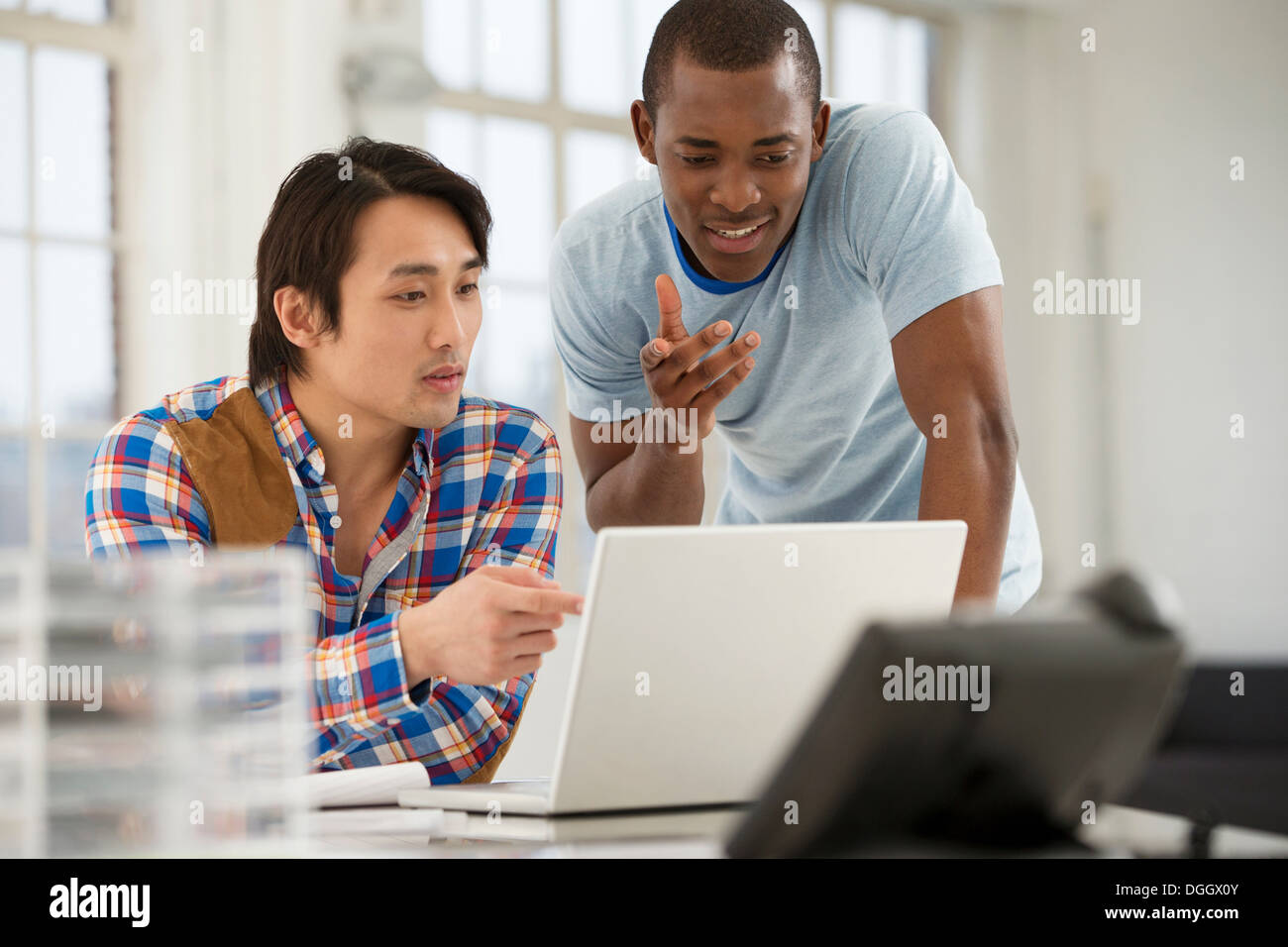 Two male colleagues using laptop Stock Photo - Alamy