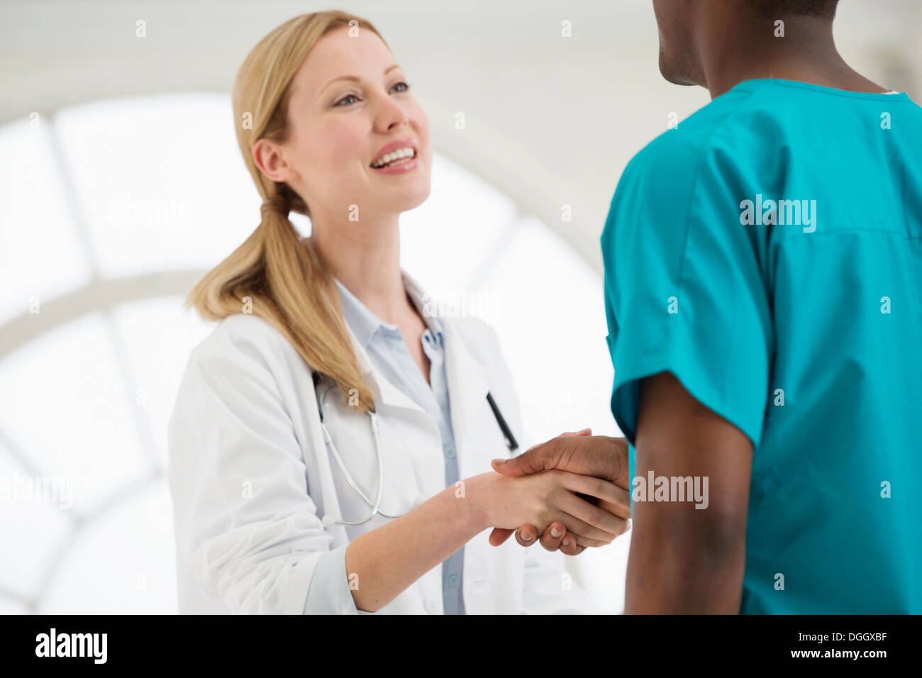 Two young doctors handshake hi-res stock photography and images - Alamy