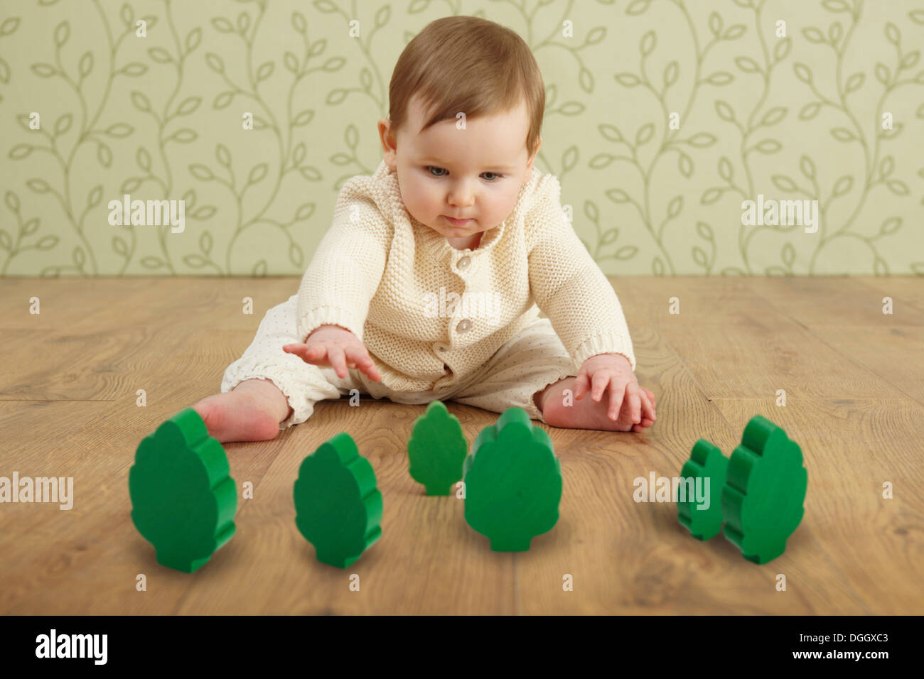 Baby girl with toy trees Stock Photo - Alamy