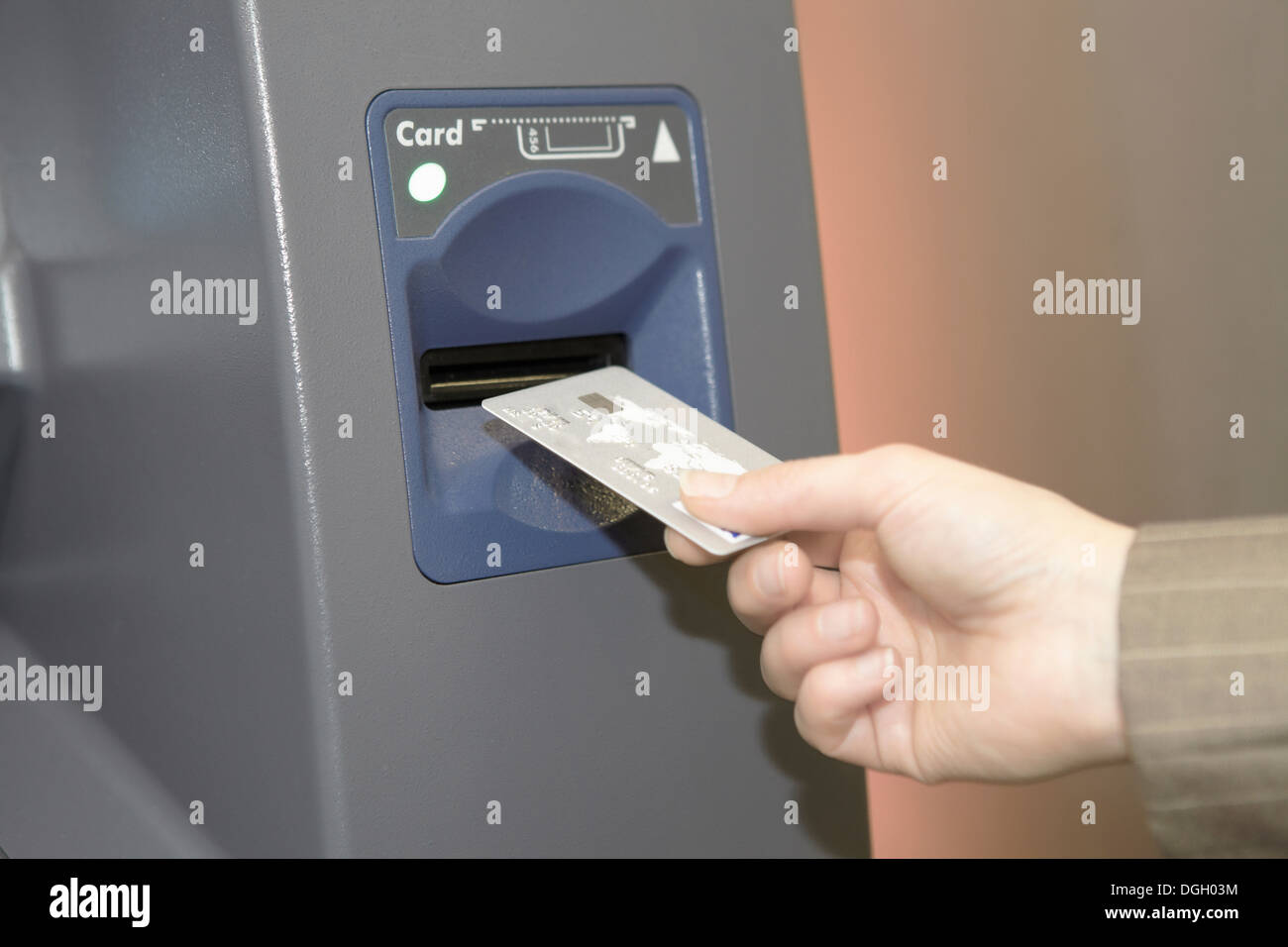 Woman inserting credit card into cashpoint Stock Photo - Alamy