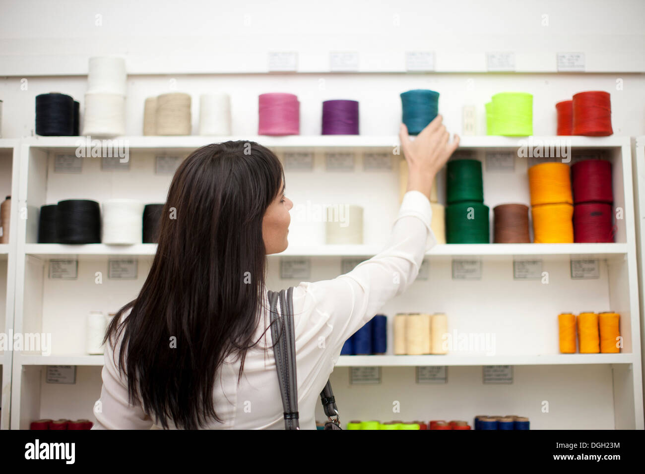 Woman choosing spool of thread in store Stock Photo - Alamy