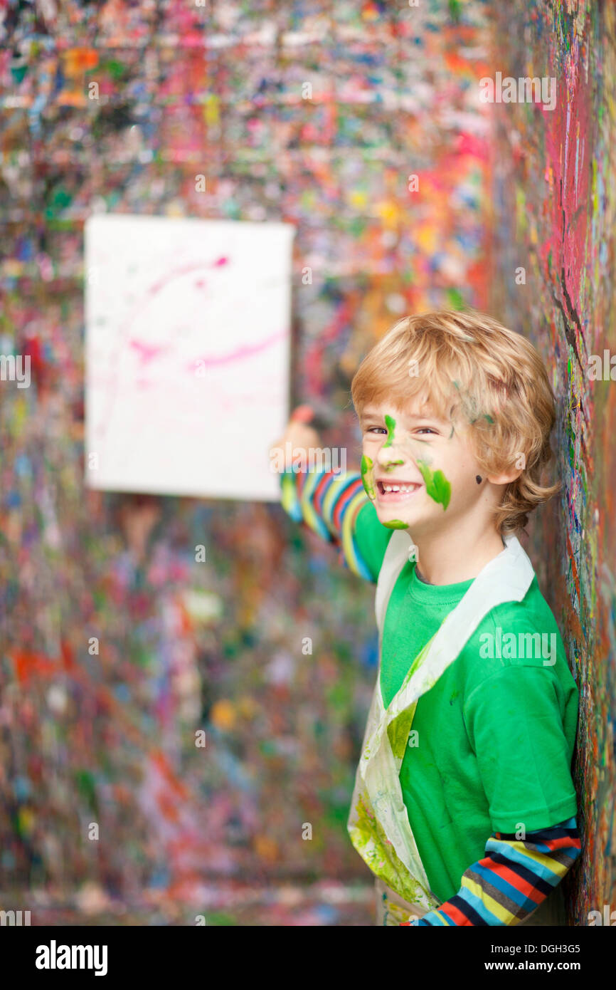 Boy pointing to painting on paint-splattered wall Stock Photo - Alamy