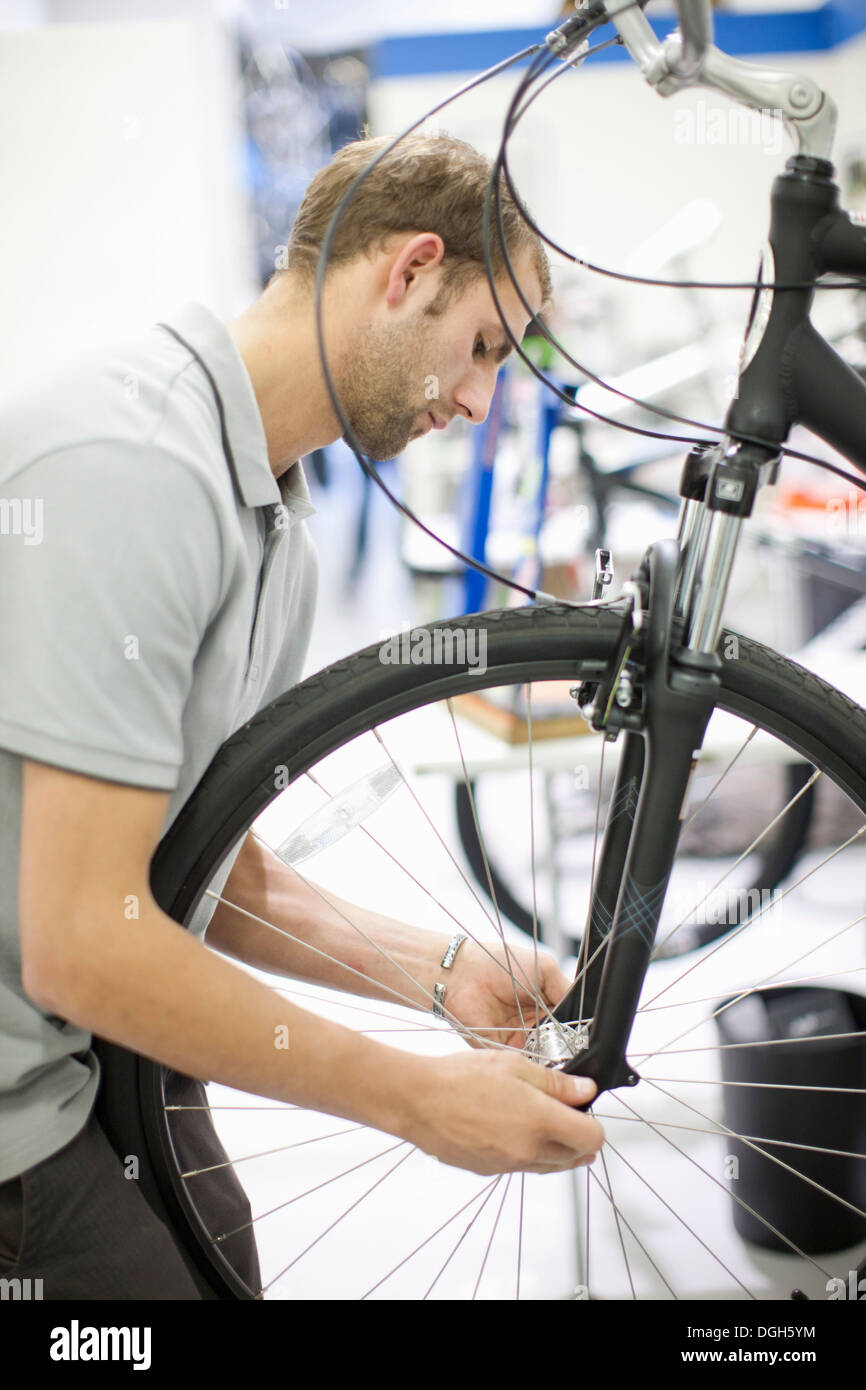 Young man working on bicycle Stock Photo - Alamy