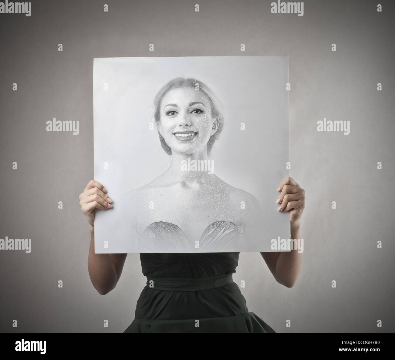 Beautiful girl covering her face with a cardboard on which is drawn her ...