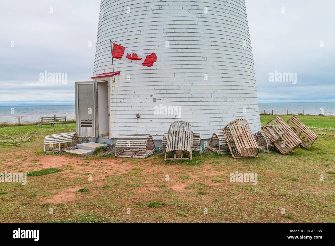 Lighthouse with wooden, old style, lobster traps leaning against the ...