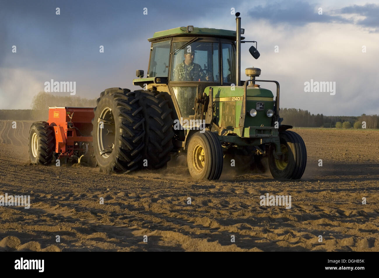 John Deere 2140 tractor pulling Tume seed drill, drilling arable field ...