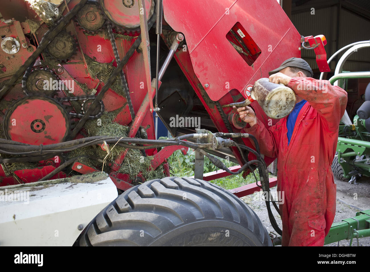 Farmer greasing chain on round baler, Sweden, july Stock Photo - Alamy