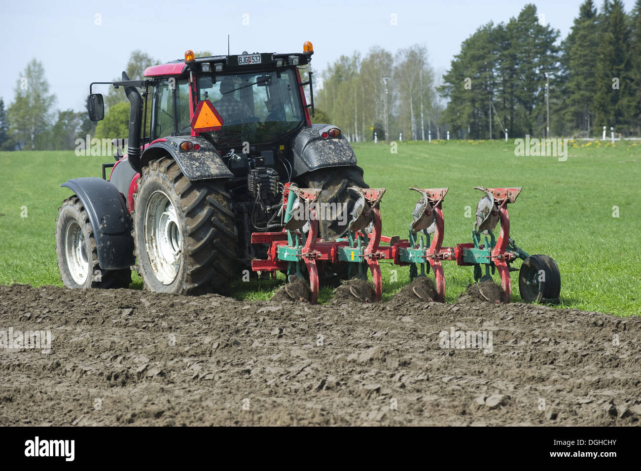 Valtra tractor ploughing field with four furrow reversible plough ...