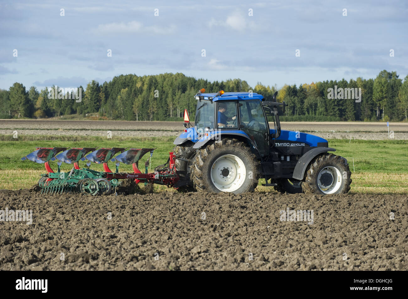 New Holland TM150 tractor with reversible plough and harrow, ploughing ...