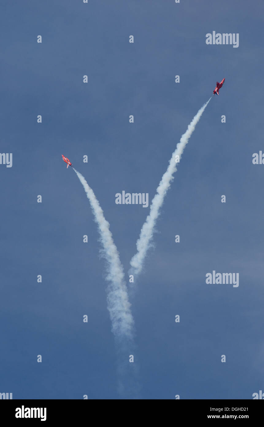 Two RAF Red Arrows perform an acrobatic maneuver in formation with ...