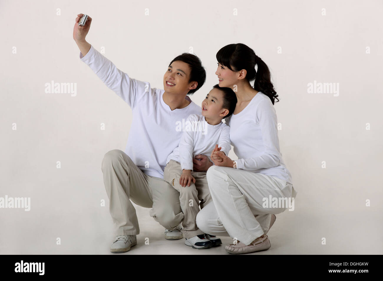 East Asian family with one child, crouching on the floor, self camera ...