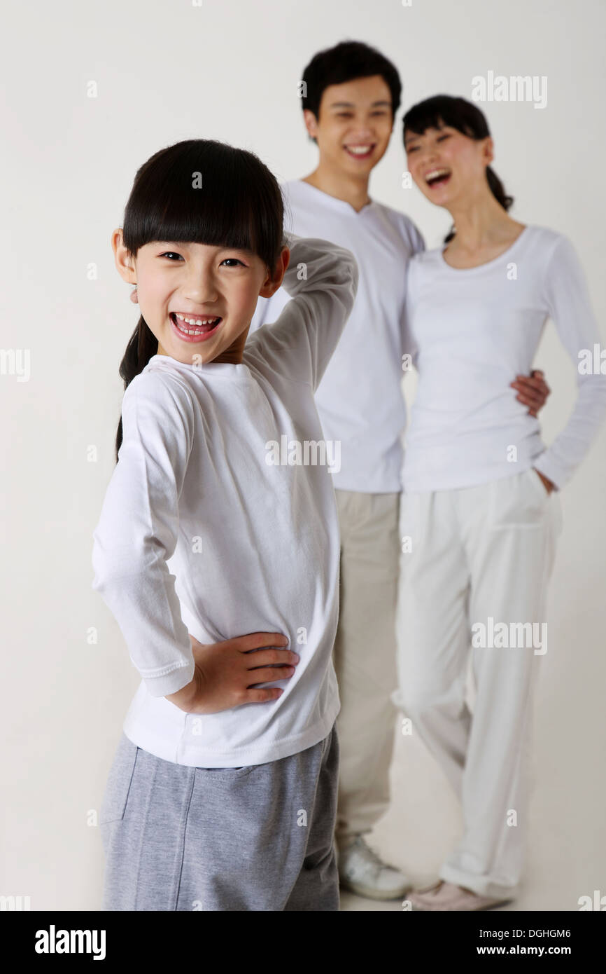 East Asian family with one child, parents embracing and smiling ...
