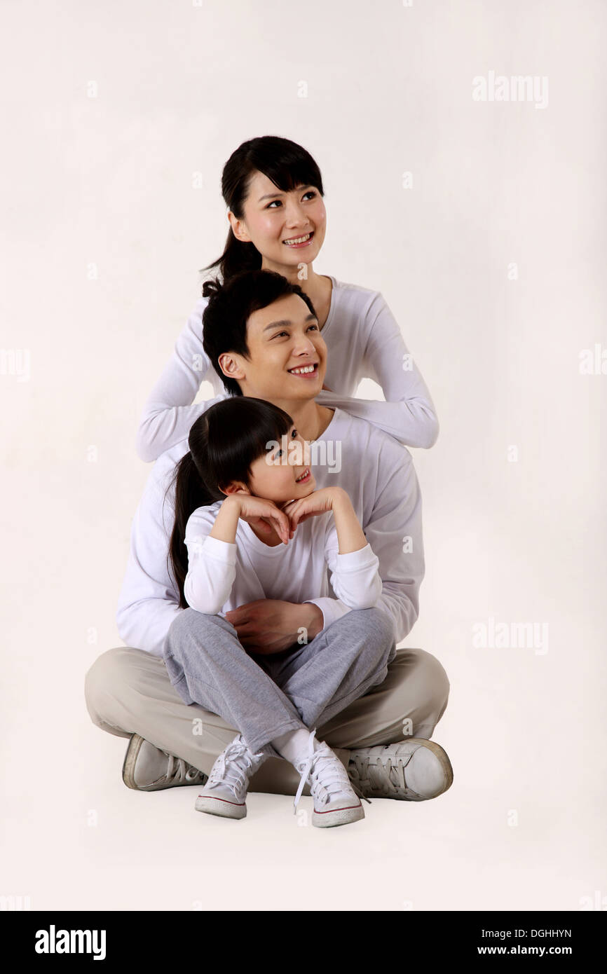 East Asian Family with One Child, Crouching, Sitting on the Floor with ...