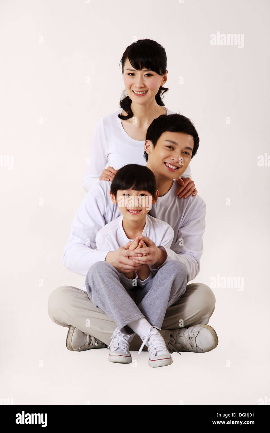 East Asian Family with One Child, Crouching, Sitting on the Floor with ...