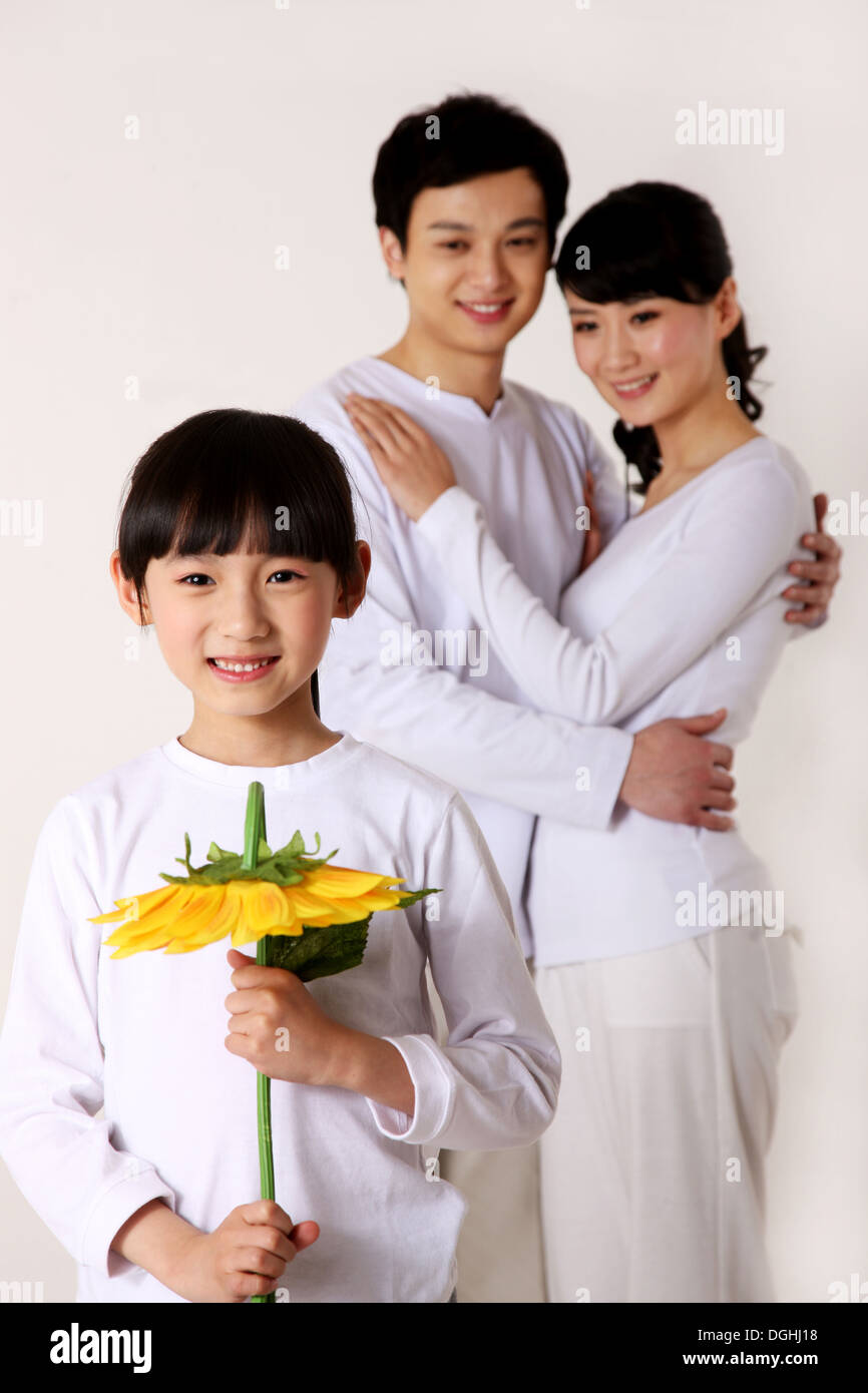 East Asian Family with One Child, Daughter Carrying Sunflower, Parents ...
