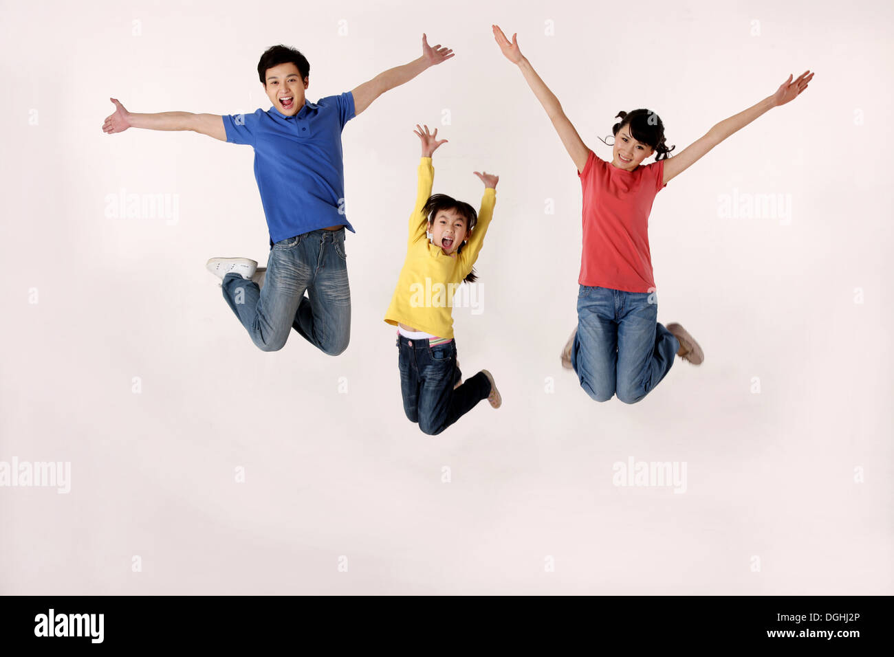 East Asian Family Jumping, Smiling, Looking at the Camera Stock Photo ...