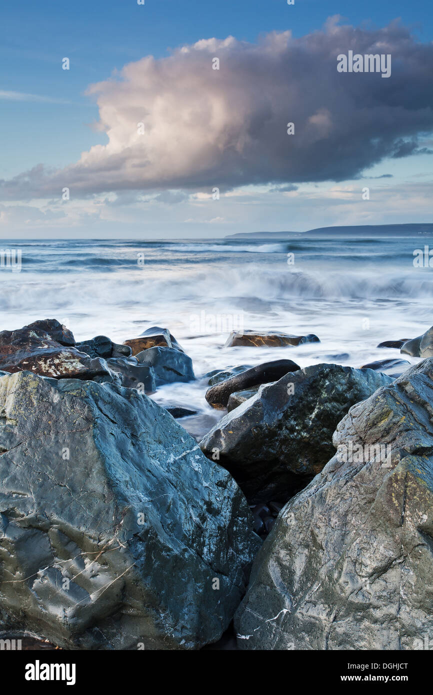 Large boulders of sea defences at bottom of pebble ridge with waves ...
