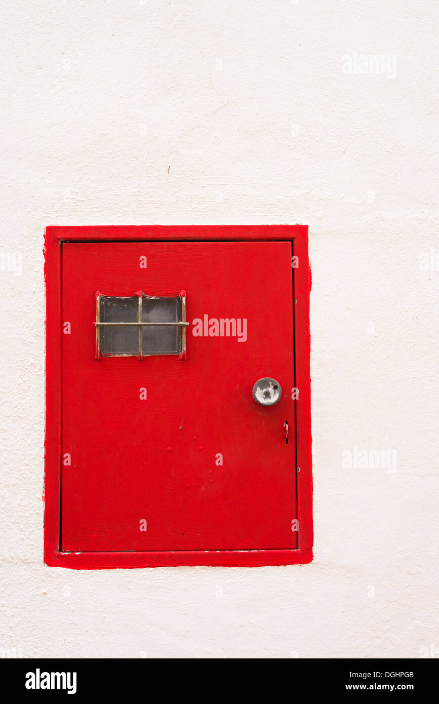 Red door for an electric meter on a whitewashed wall Stock Photo - Alamy