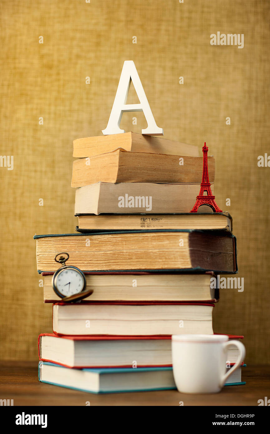 old looking books in a pile next to a cup Stock Photo - Alamy