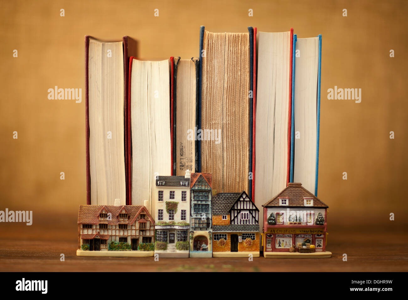 several books in a row behind miniature houses Stock Photo - Alamy