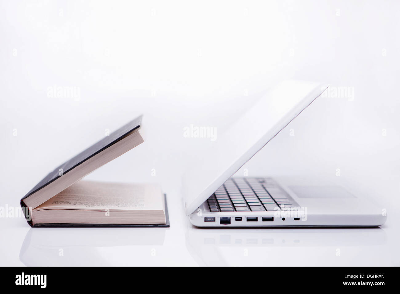 an open laptop next to an open book Stock Photo - Alamy