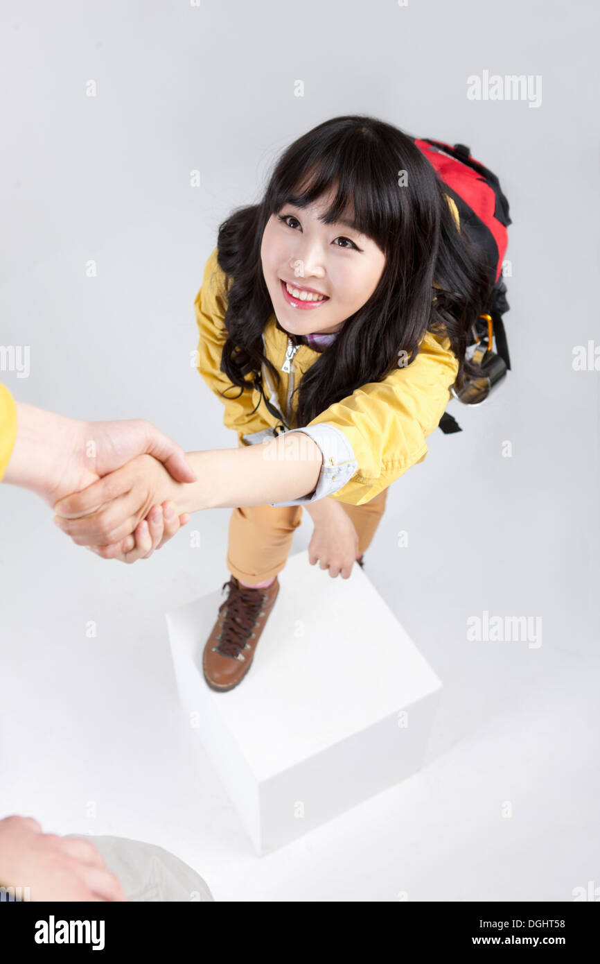 a hiker man helping a hiker girl on a step Stock Photo - Alamy