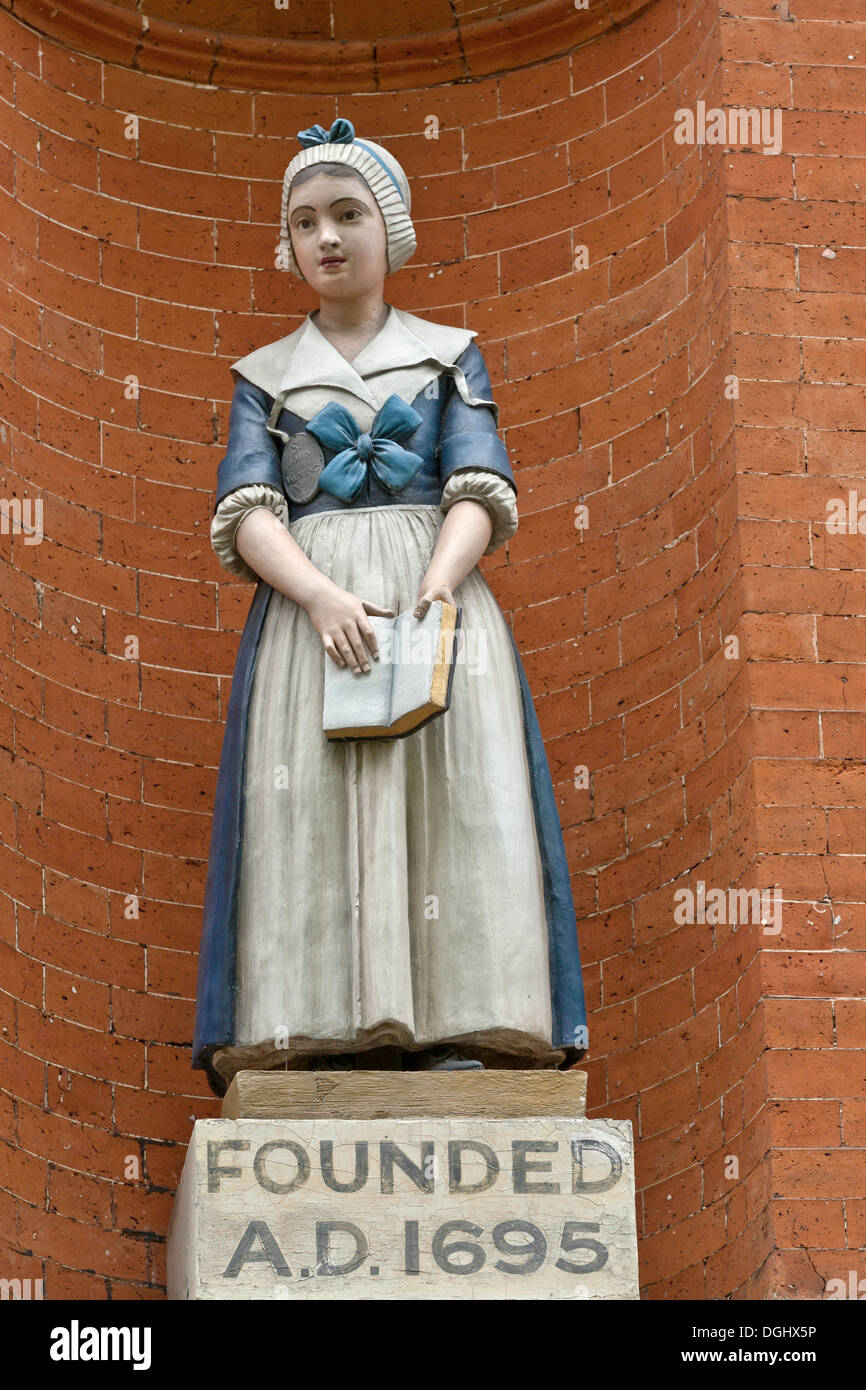 Statue of a girl pupil dressed in the uniform of the time in front of ...