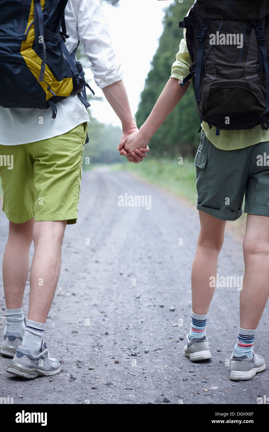 a couple walking hand in hand in the nature Stock Photo - Alamy