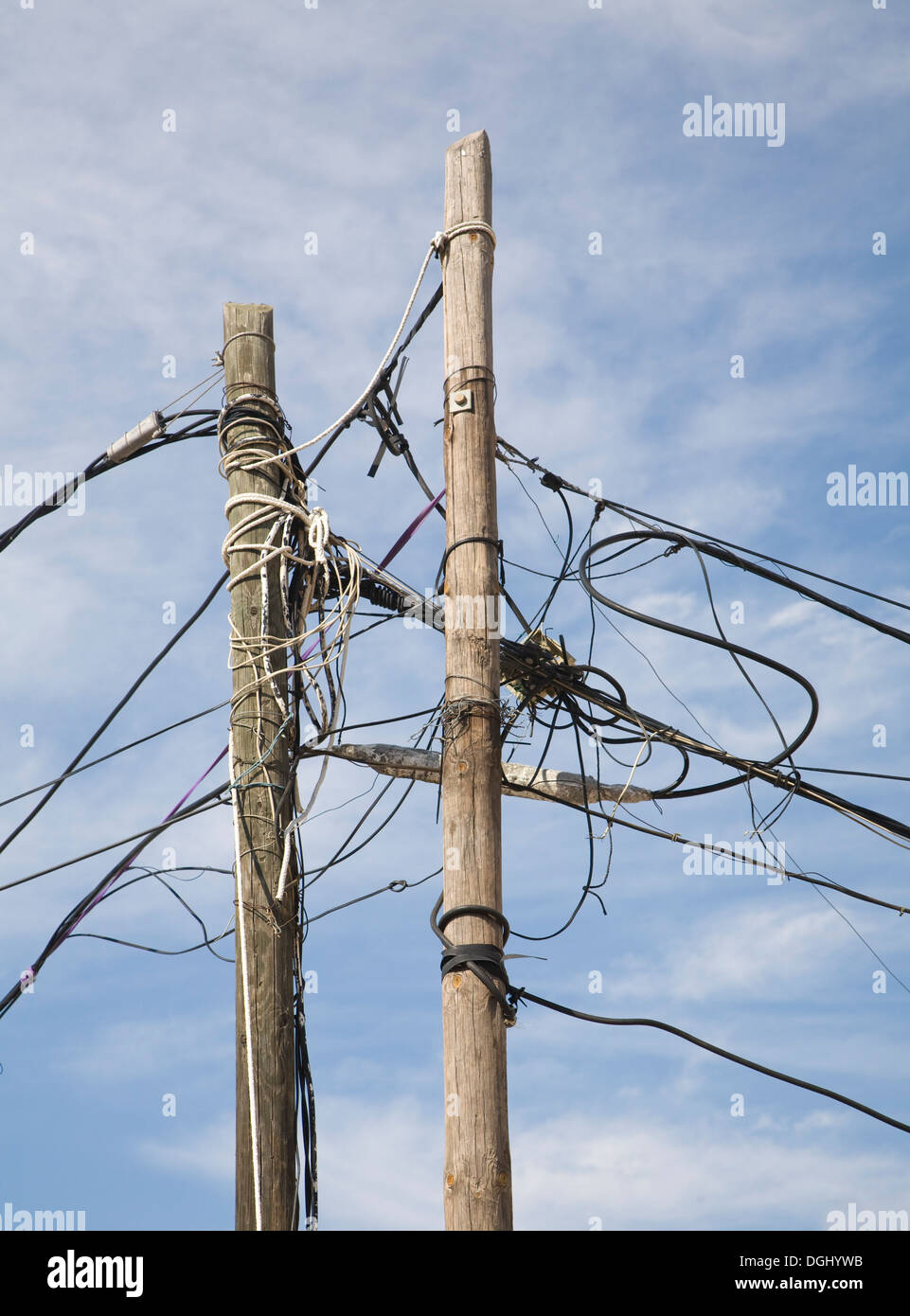 Confused tangle electricity phone line cables telegraph pole blue sky ...