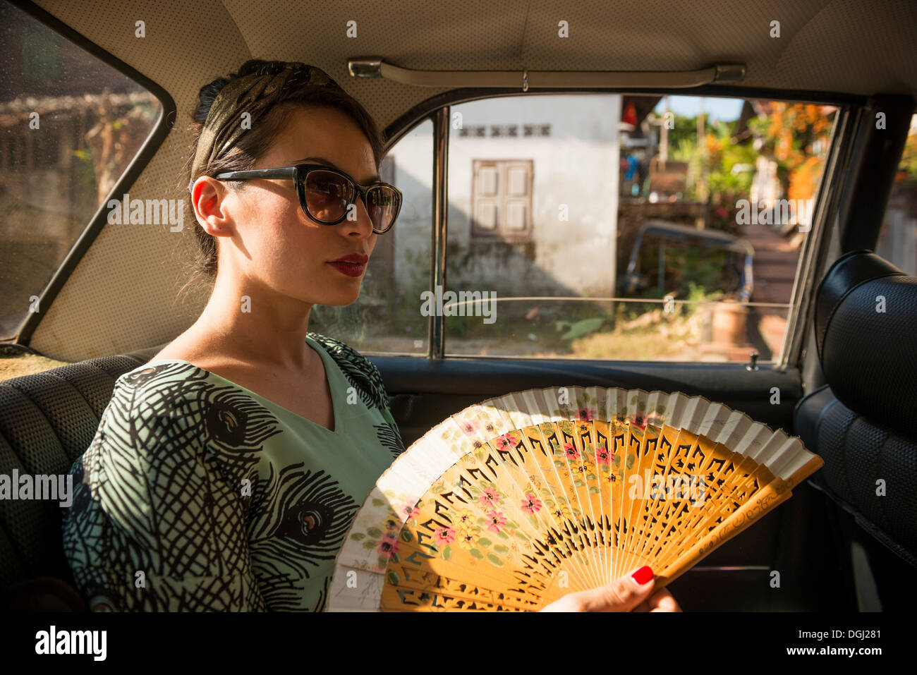 Woman in taxi holding fan Stock Photo - Alamy