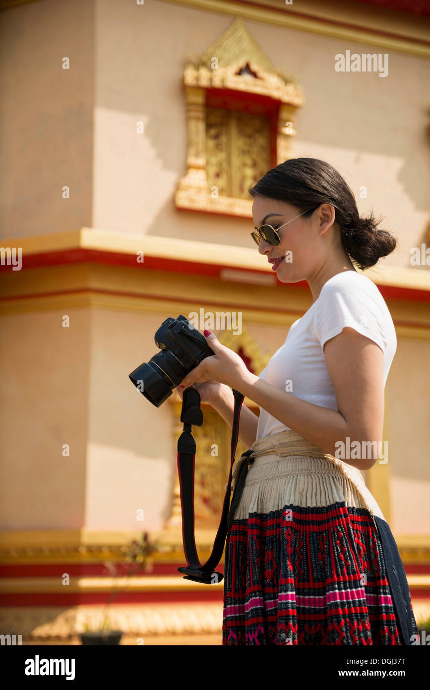 Woman holding camera outside building Stock Photo - Alamy