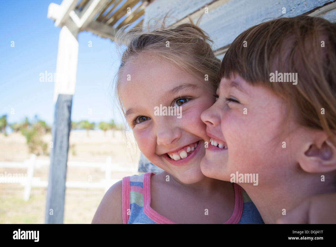 Portrait of two girls cheek to cheek smiling Stock Photo - Alamy