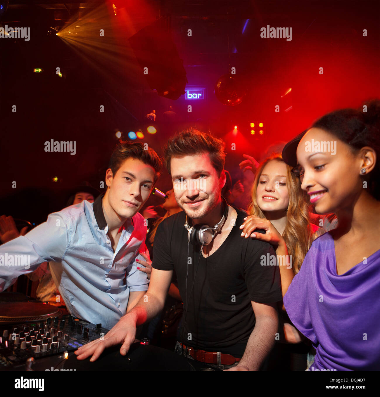 Disc Jockey surrounded by group of people Stock Photo - Alamy